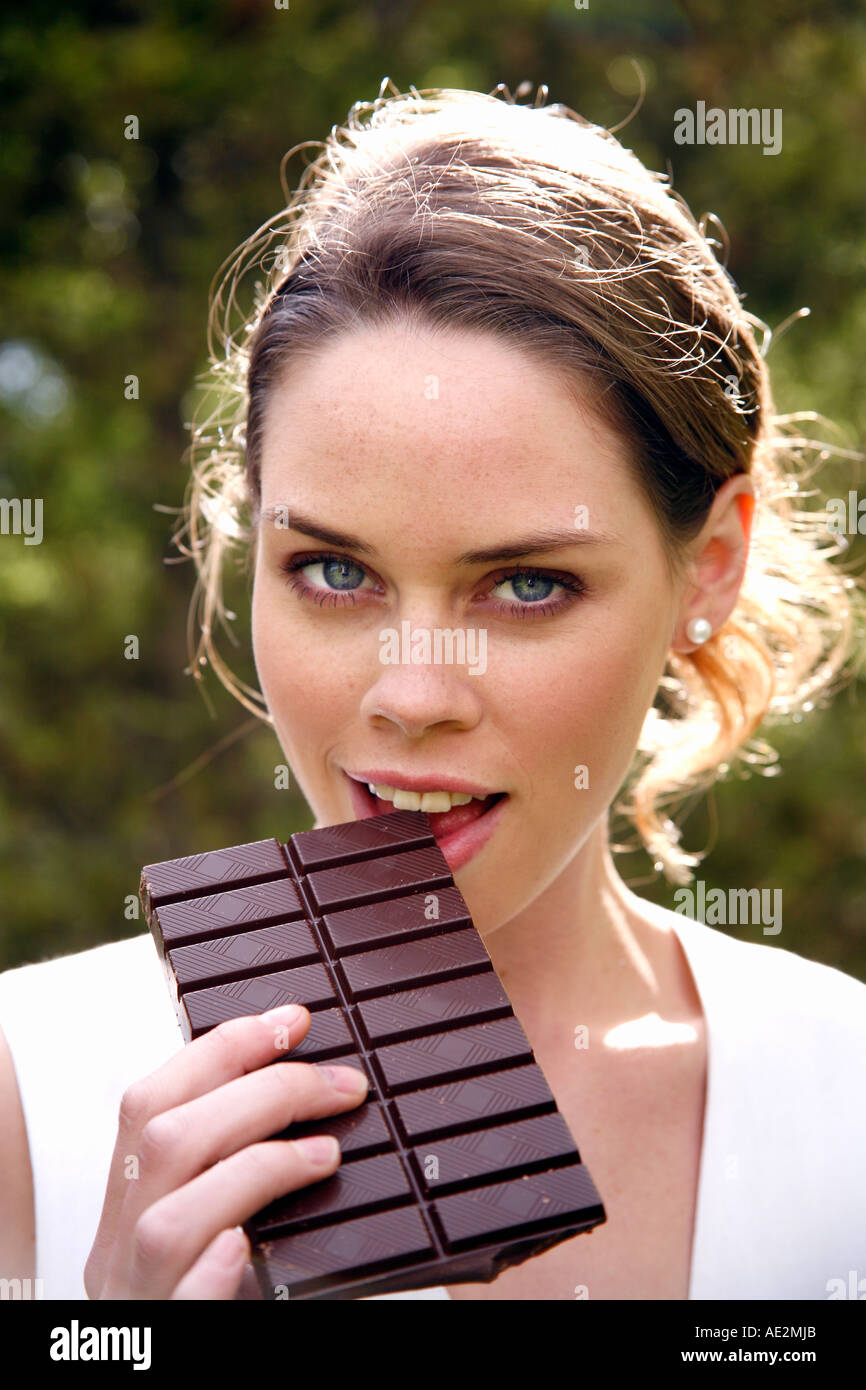 Young woman eating chocolate Stock Photo - Alamy