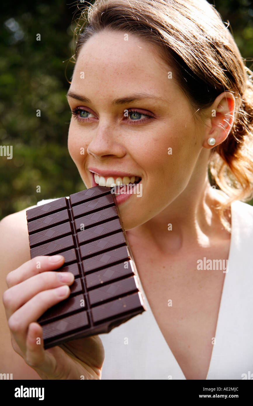 Young woman eating chocolate Stock Photo - Alamy