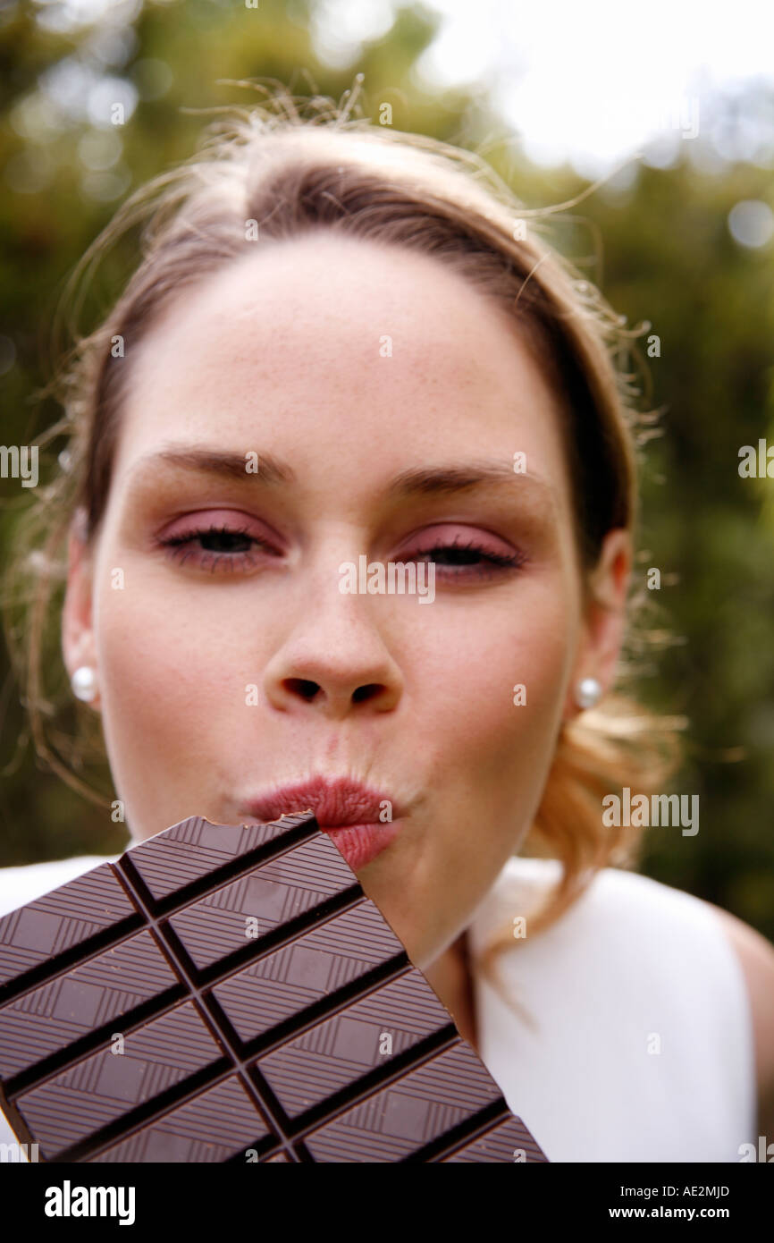 Young woman eating chocolate Stock Photo - Alamy