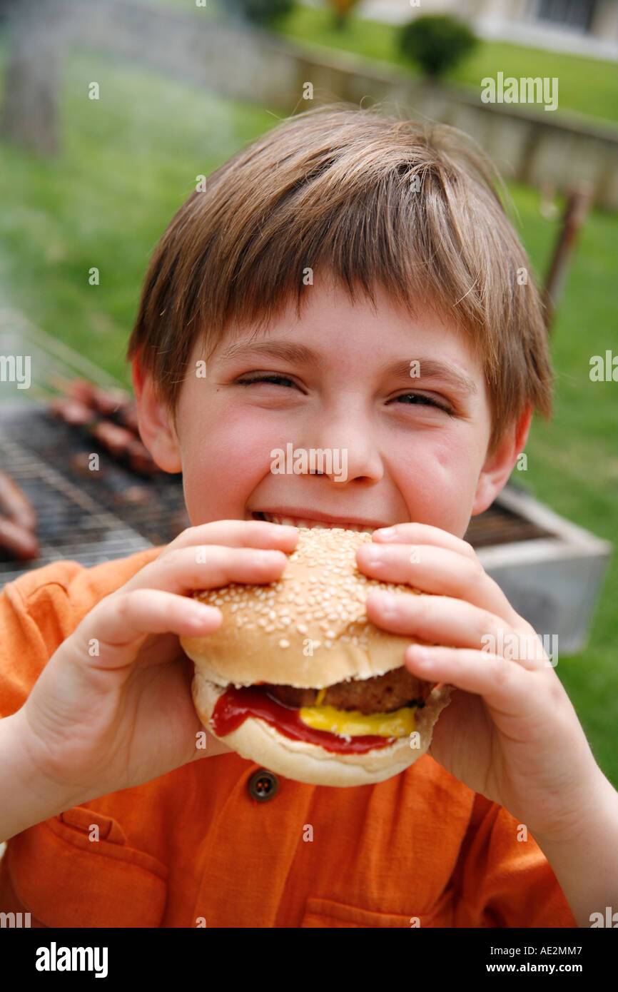Little boy eating a hamburger Stock Photo - Alamy