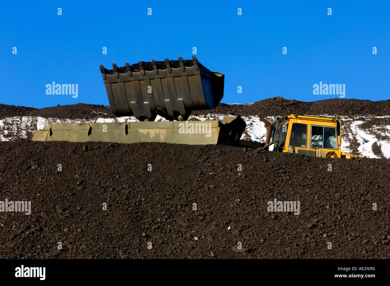 Slag dump slope stabilizing operation with truck being loaded, Greater ...