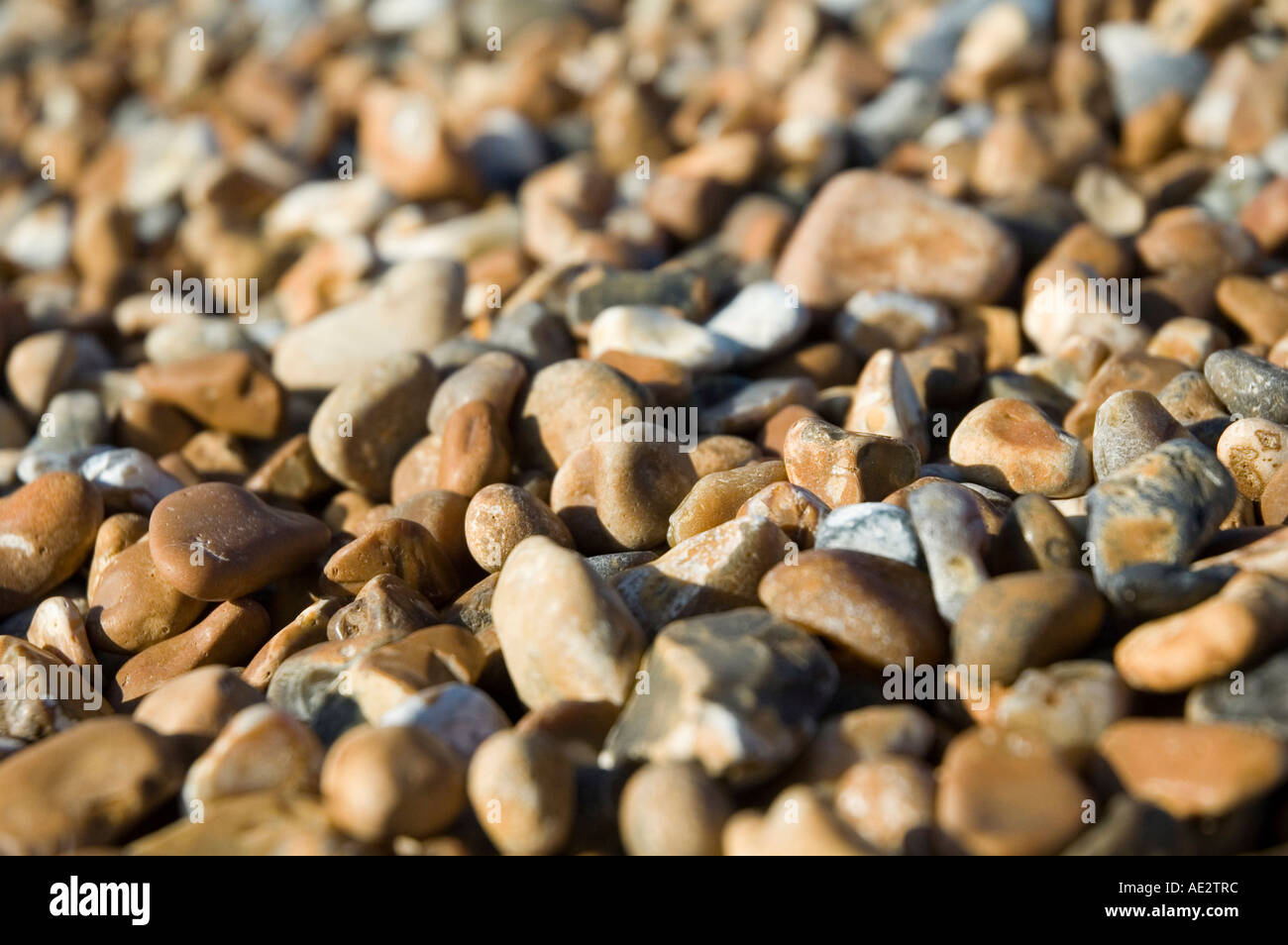 Pebbles on beach with central focus point leaving surrounding area ...