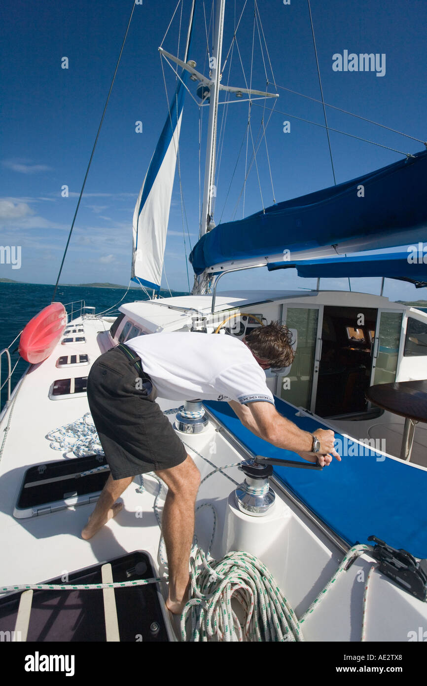 Skipper working on a luxury catamaran in the tropical waters of Fiji in ...