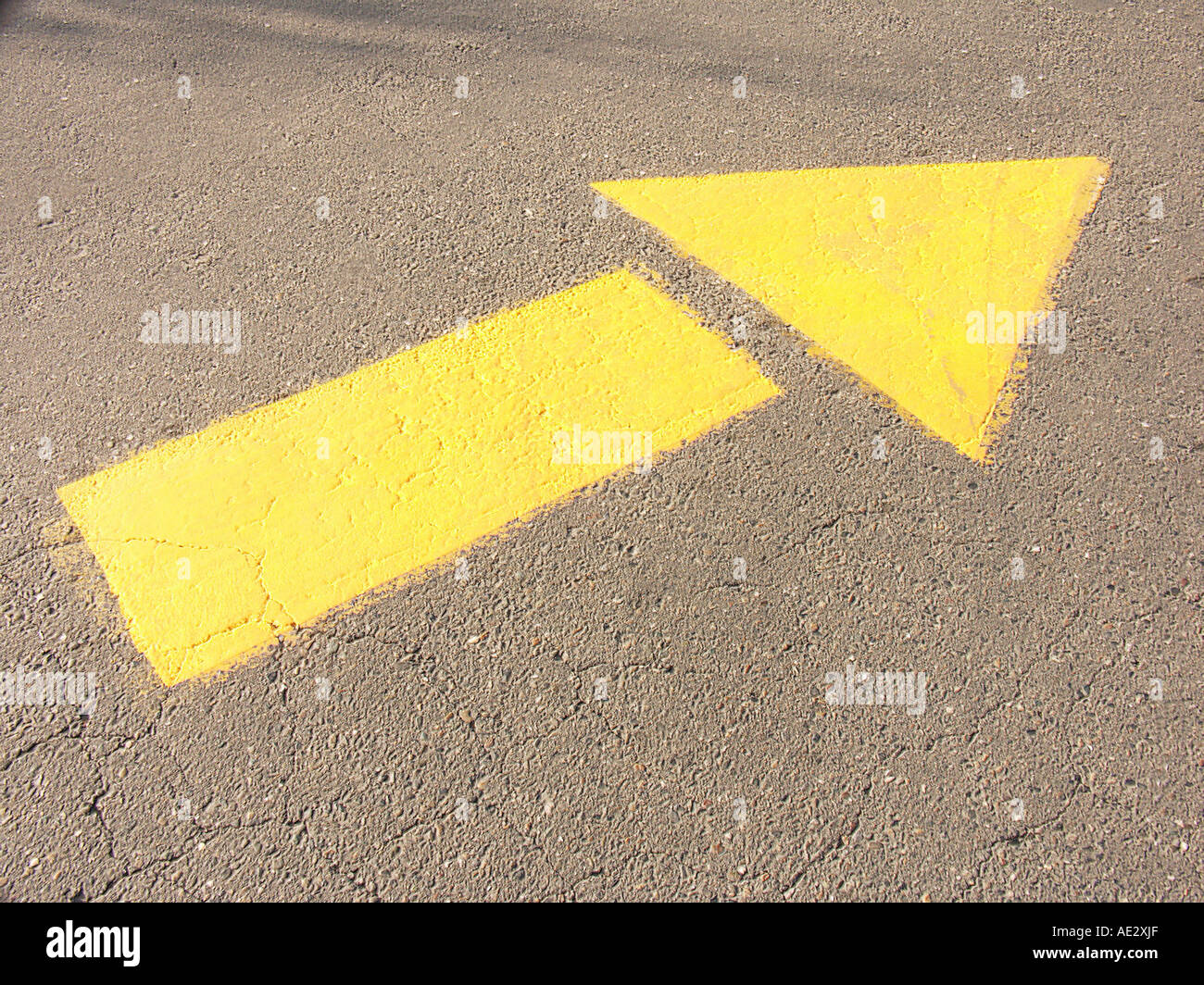 Yellow directional arrow painted on an asphalt road Stock Photo - Alamy