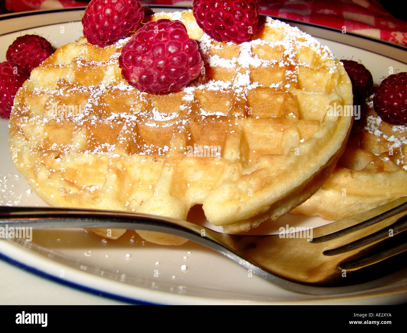 Waffles garnished with raspberries and powdered sugar Stock Photo - Alamy