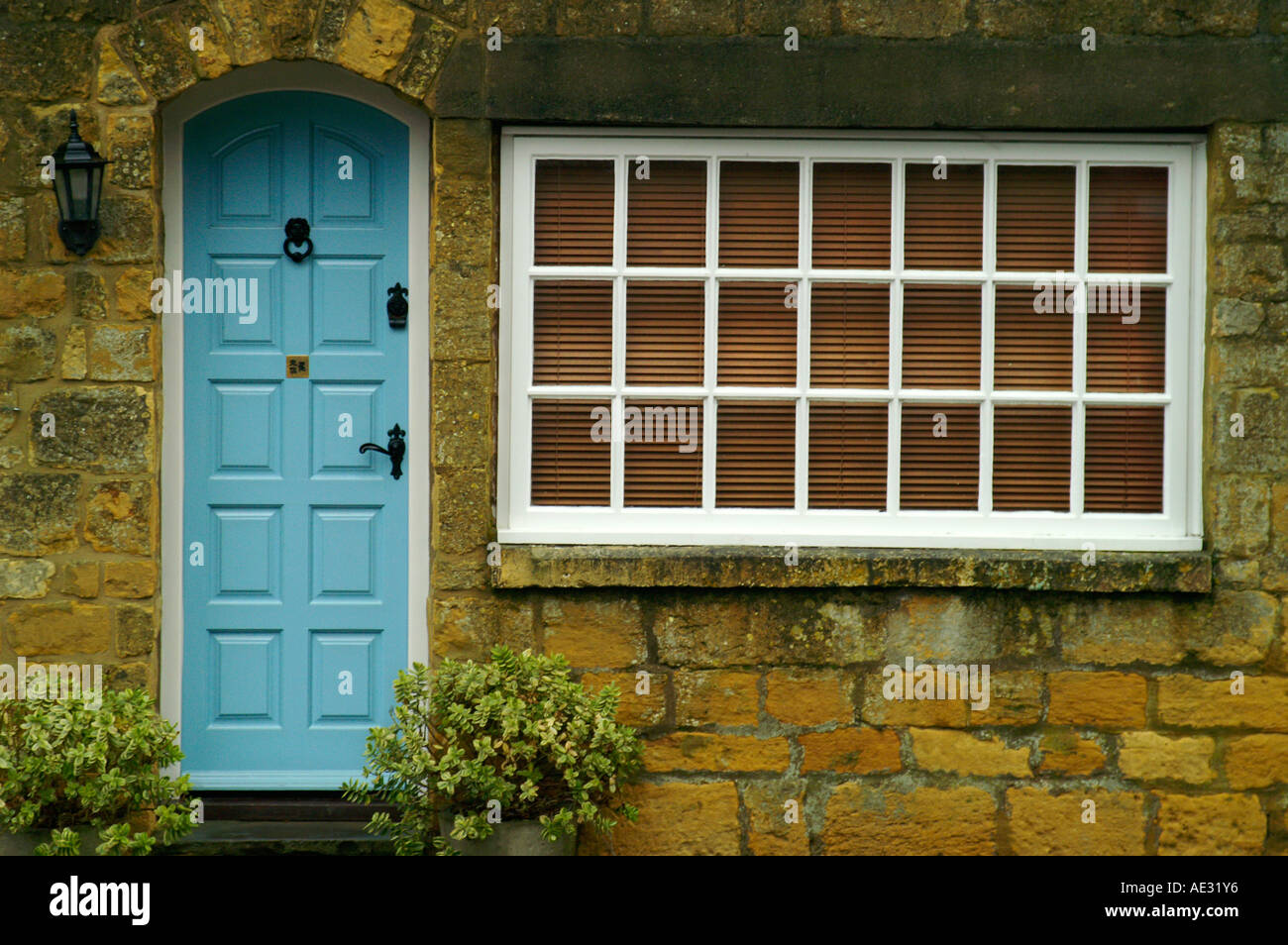 Stone wall and blue doors and tiled window in Broadway Village ...