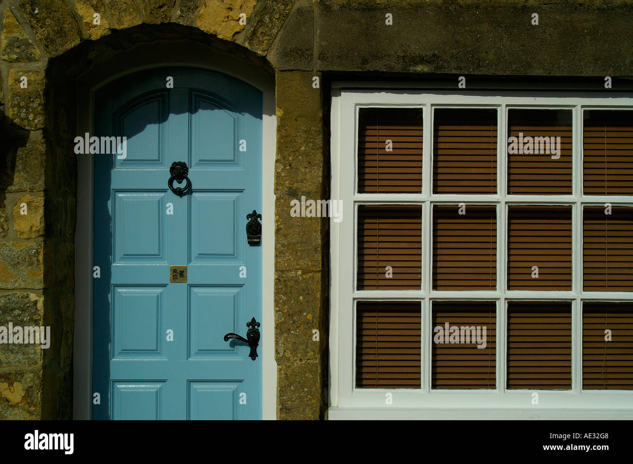Stone wall and blue doors and tiled window Stock Photo - Alamy