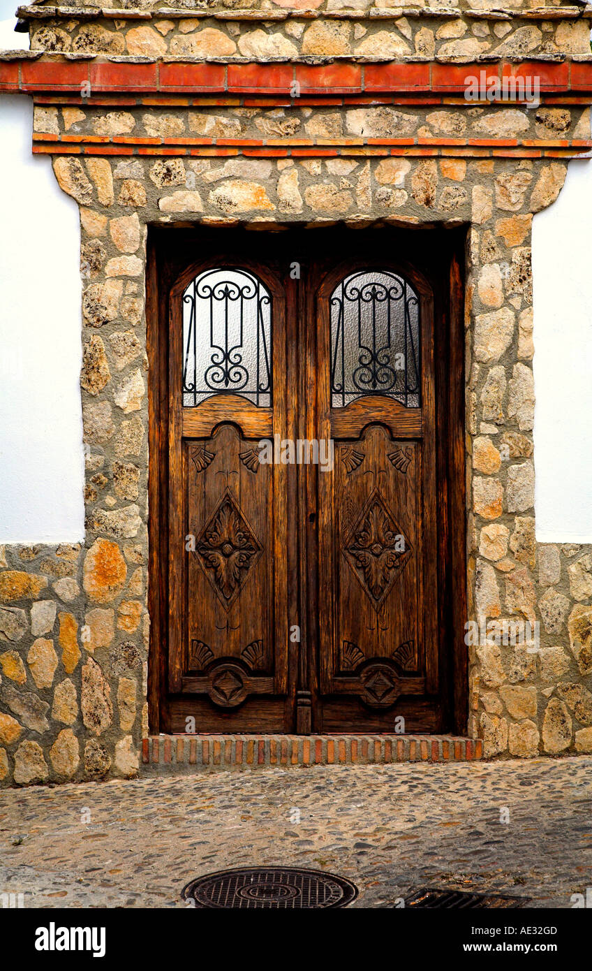 Details for an ornate wooden door surrounded with decorative stone work ...