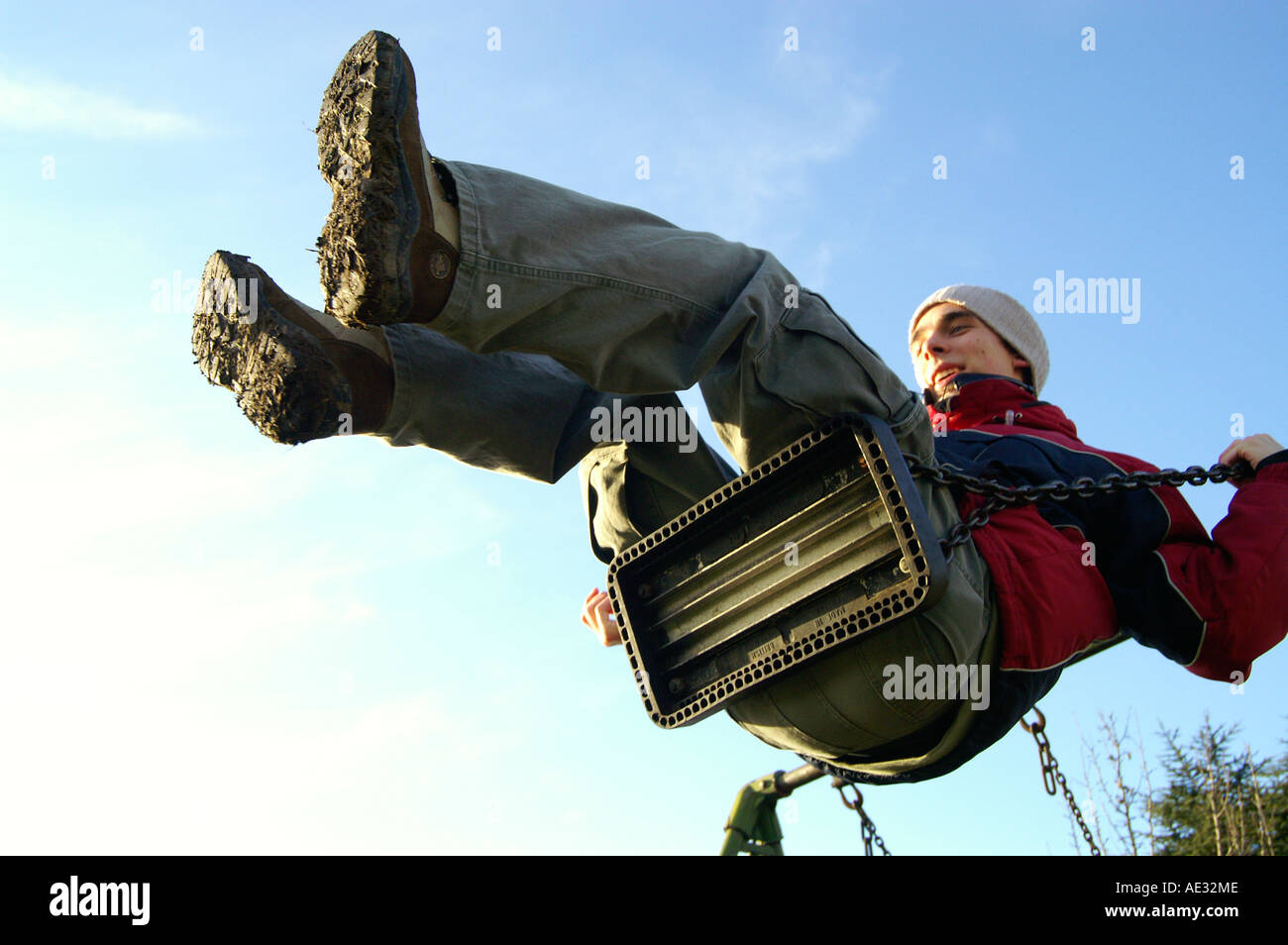 Man in 20s swinging on a swing, children playground outdoors Stock ...