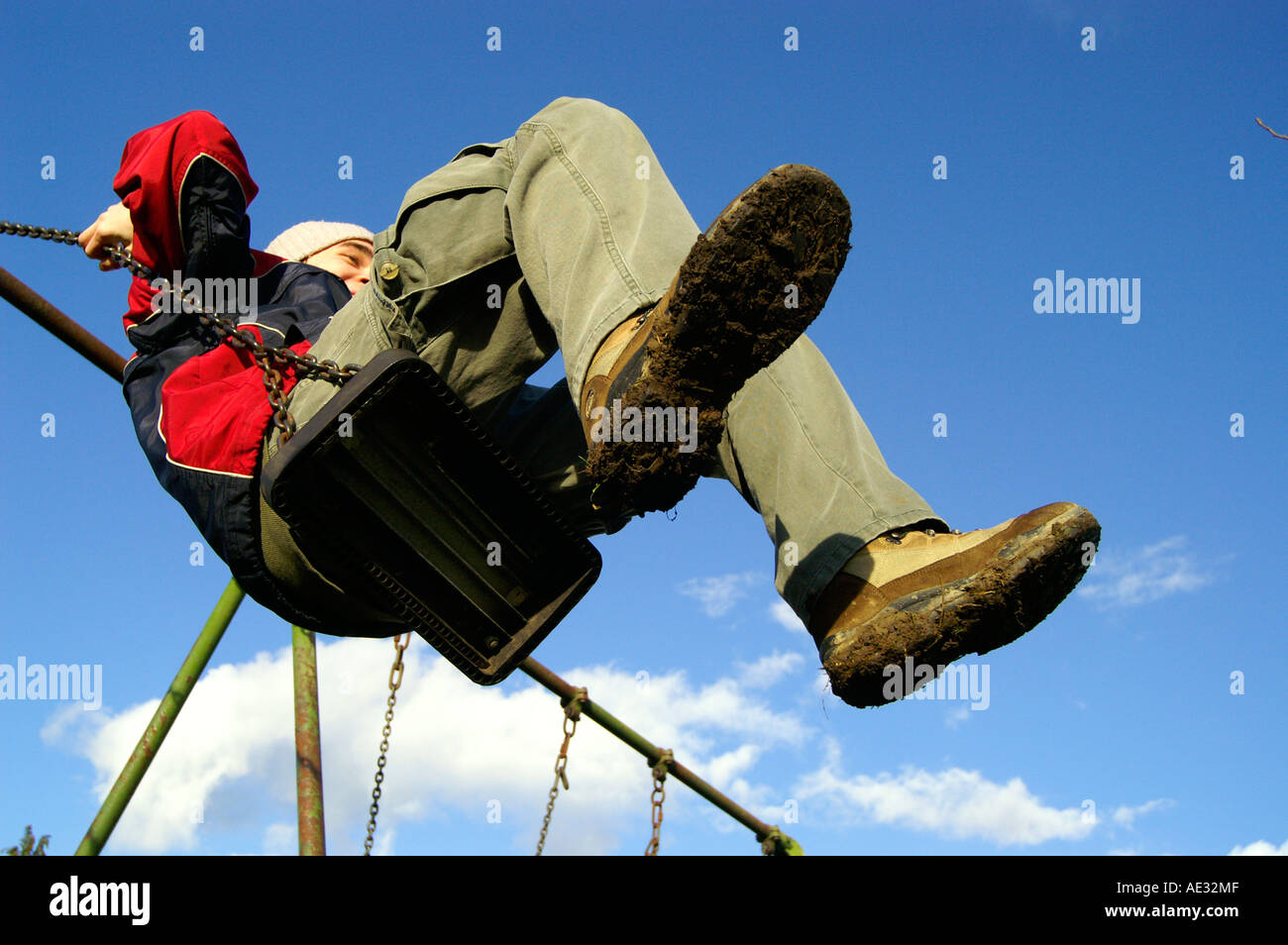 Man in 20s swinging on a swing, children playground outdoors Stock ...