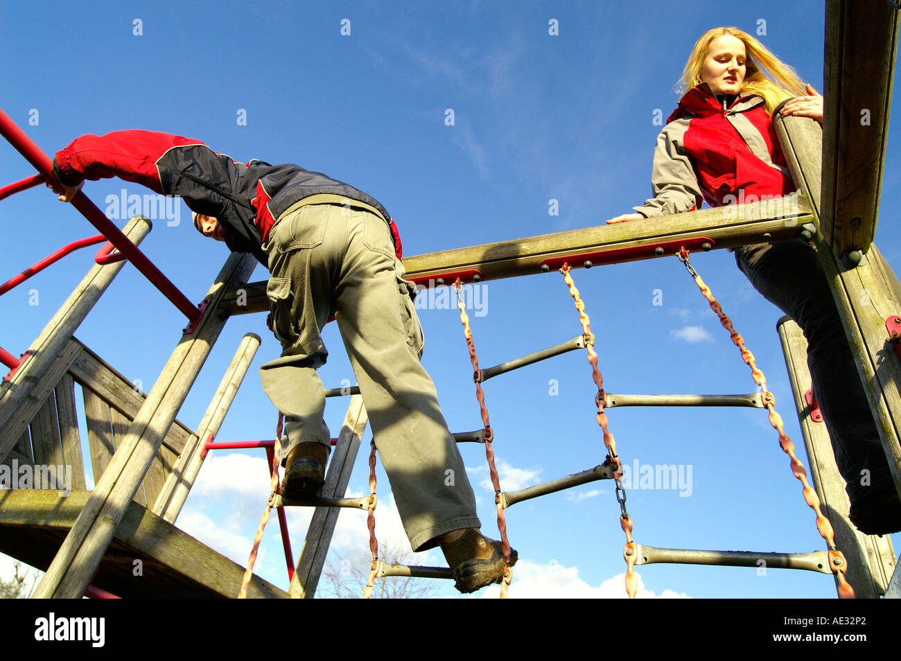 Man and woman in 20s climbing, children playground outdoors Stock Photo ...