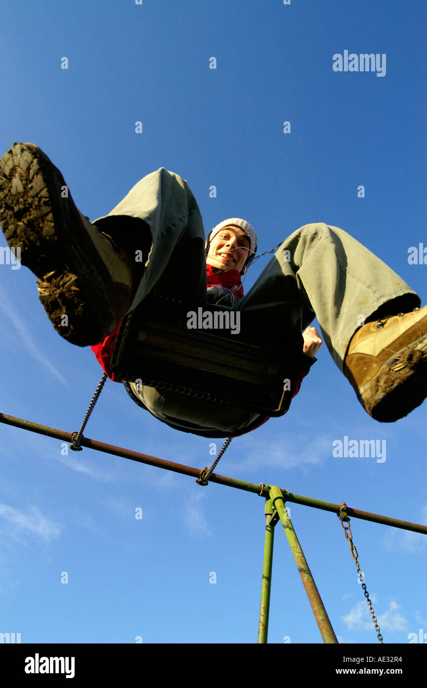 Man in 20s swinging on a swing, children playground outdoors Stock ...