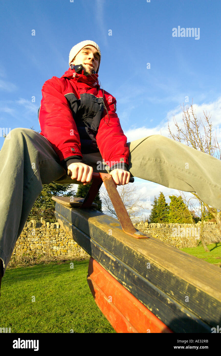 Man in 20s swinging on a seesaw, children playground outdoors Stock ...