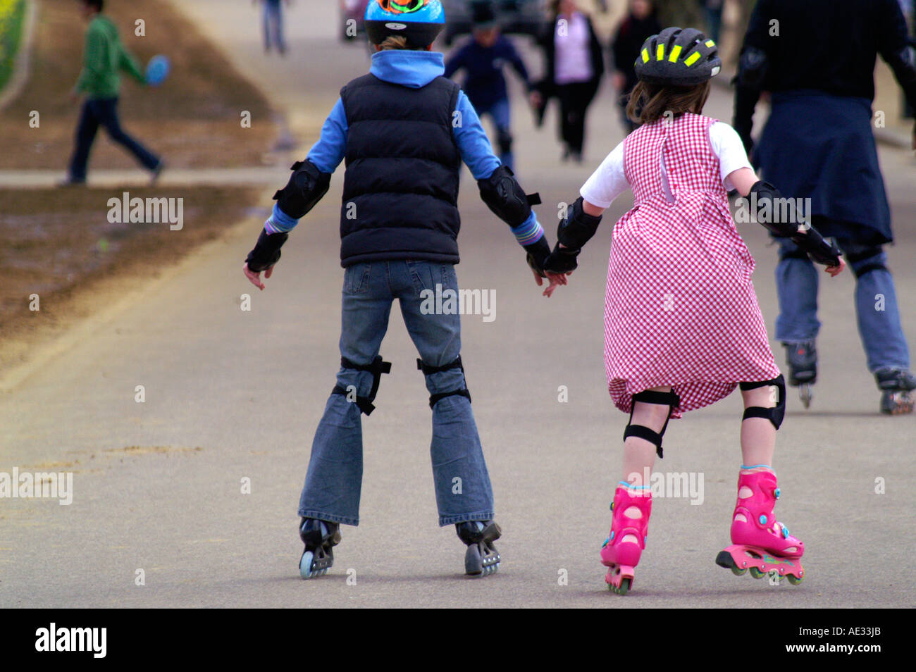 Two children, inline skating in Hyde Park, London Stock Photo - Alamy