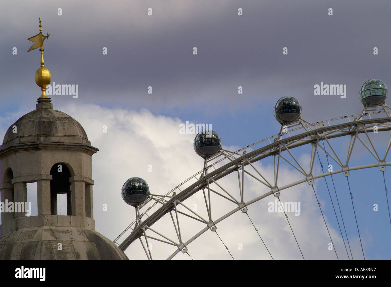 London eye capsules over historical building and cloudy blue sky ...