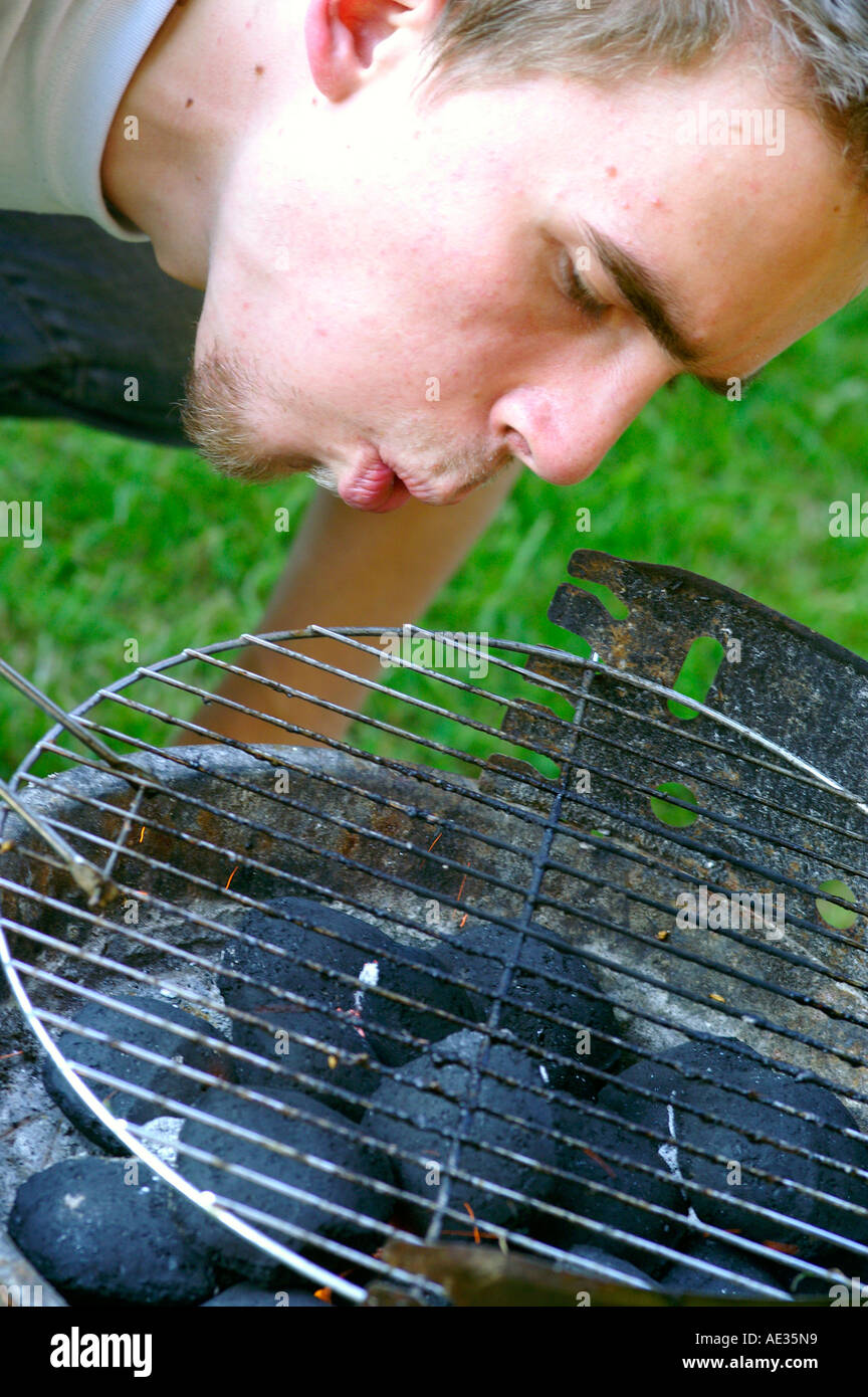 Man blowing barbecue coal Stock Photo - Alamy