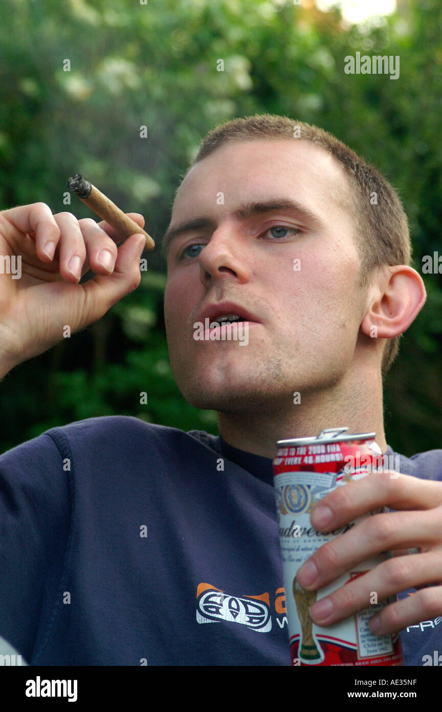 Young man smoking cigar and drinking beer can outdoors Stock Photo - Alamy