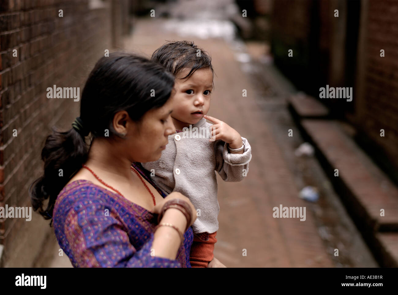 Woman carrying a baby in Nepal Stock Photo - Alamy