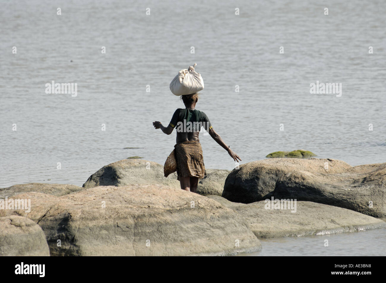 Woman carrying rocks on head hi-res stock photography and images - Alamy