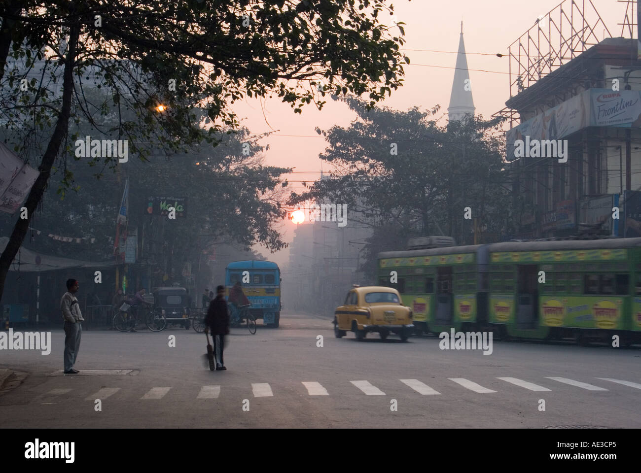 Street scene in Calcutta at sunrise depicting may modes of transport ...