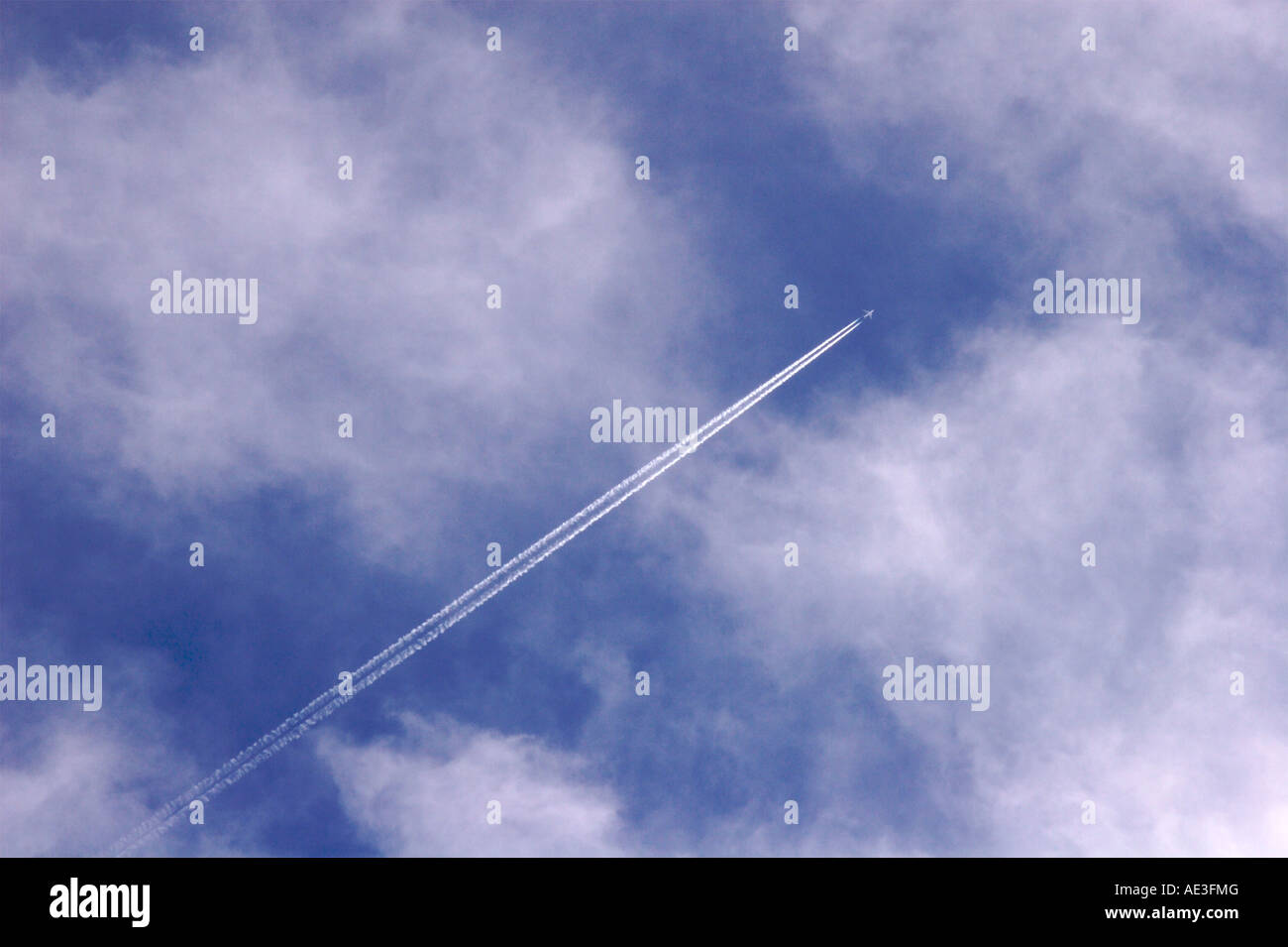 Jet leaving contrail among clouds Stock Photo - Alamy