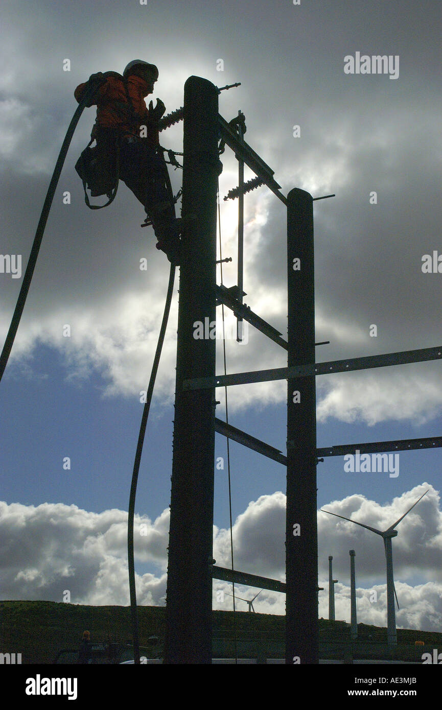 Engineer constructing wireing up a tranformer at electricty sub station ...