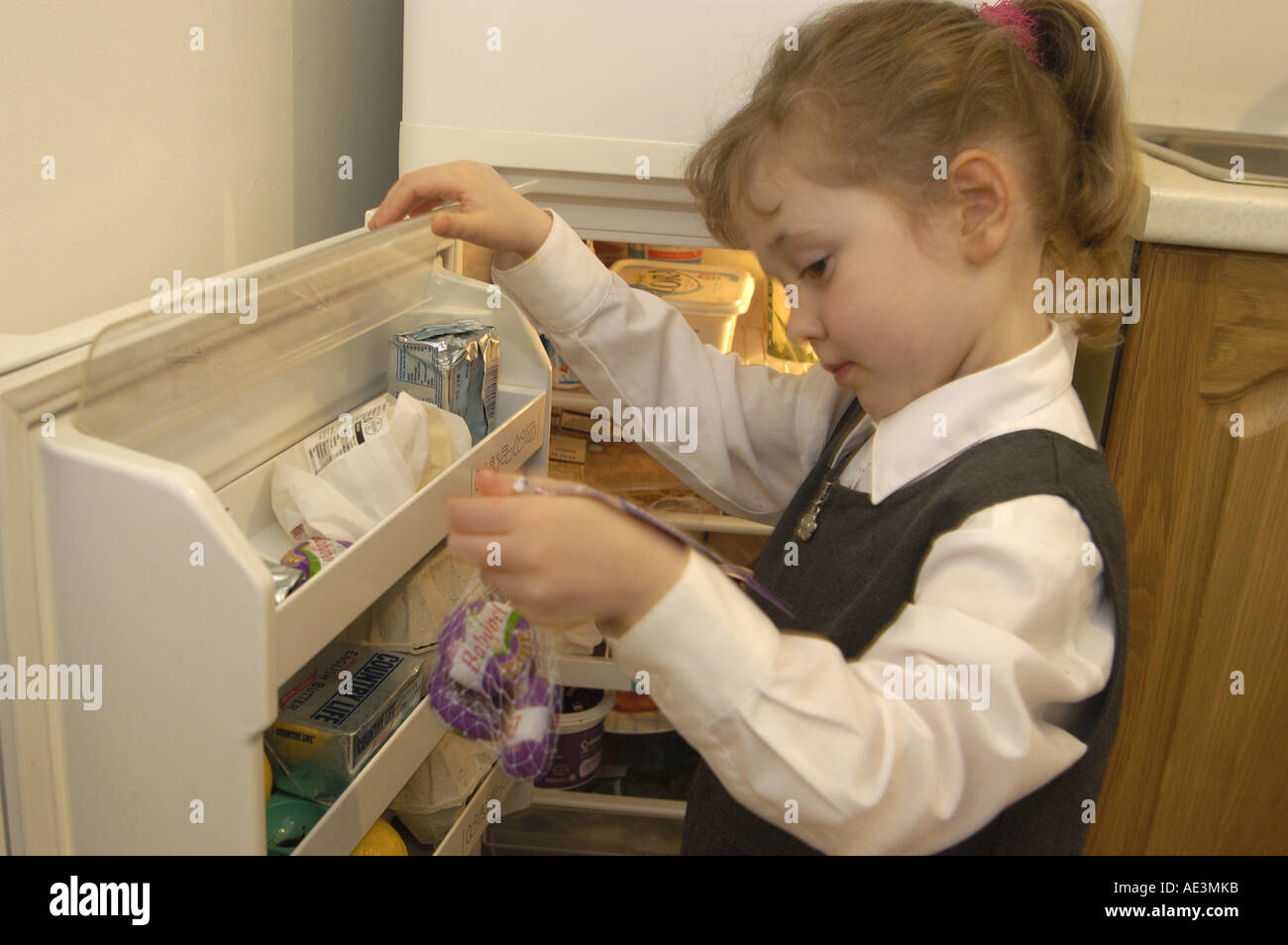 Child opening the door of a fridge Stock Photo - Alamy