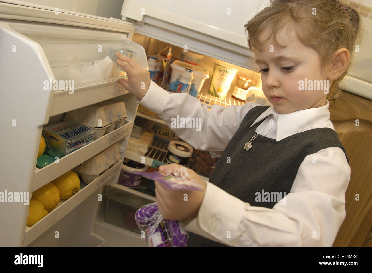 Child opening the door of a fridge Stock Photo - Alamy