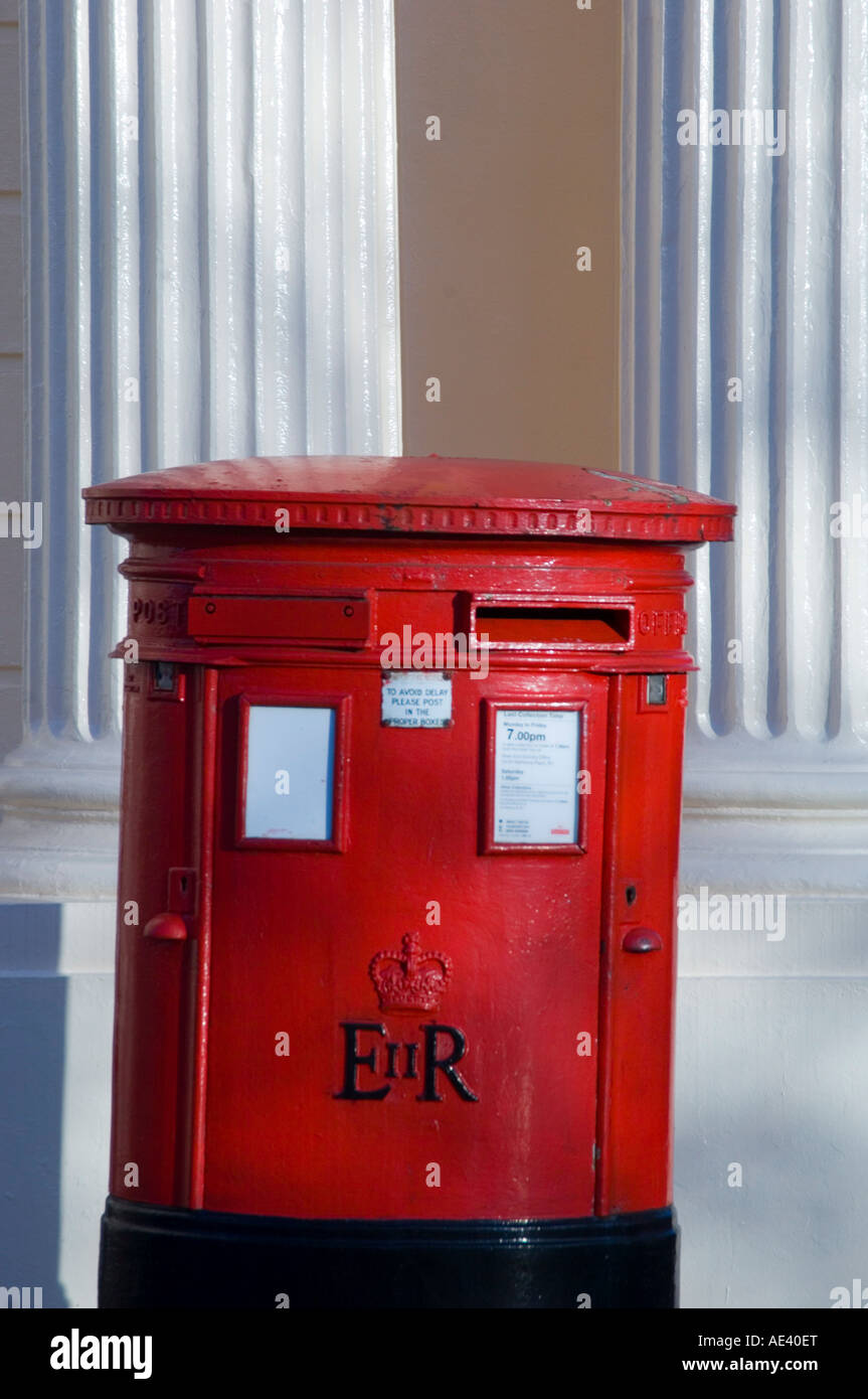 A traditional British red post box in front of cream pillars of a John ...