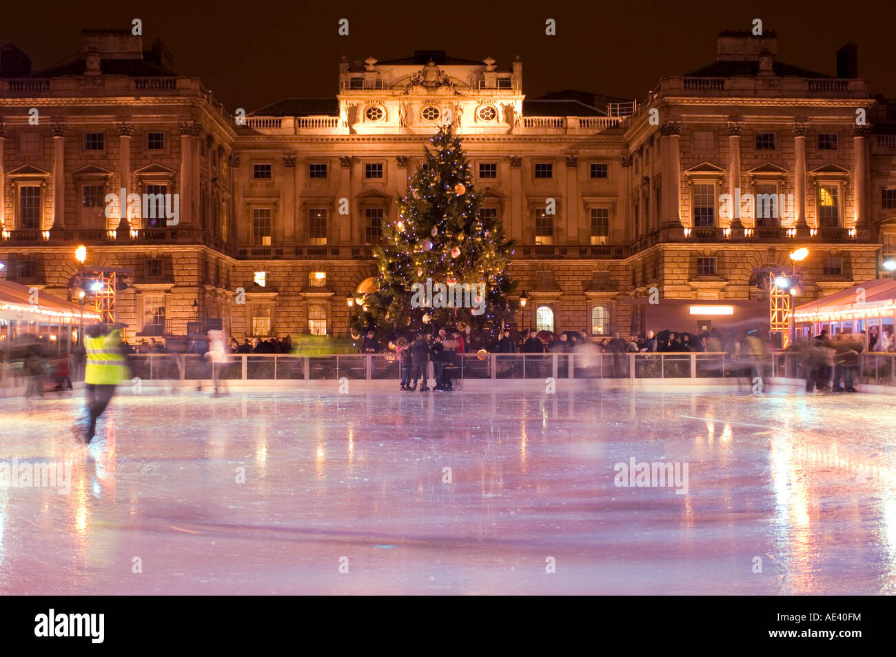 Skaters on the ice rink at Somerset House with a Christmas tree in the ...