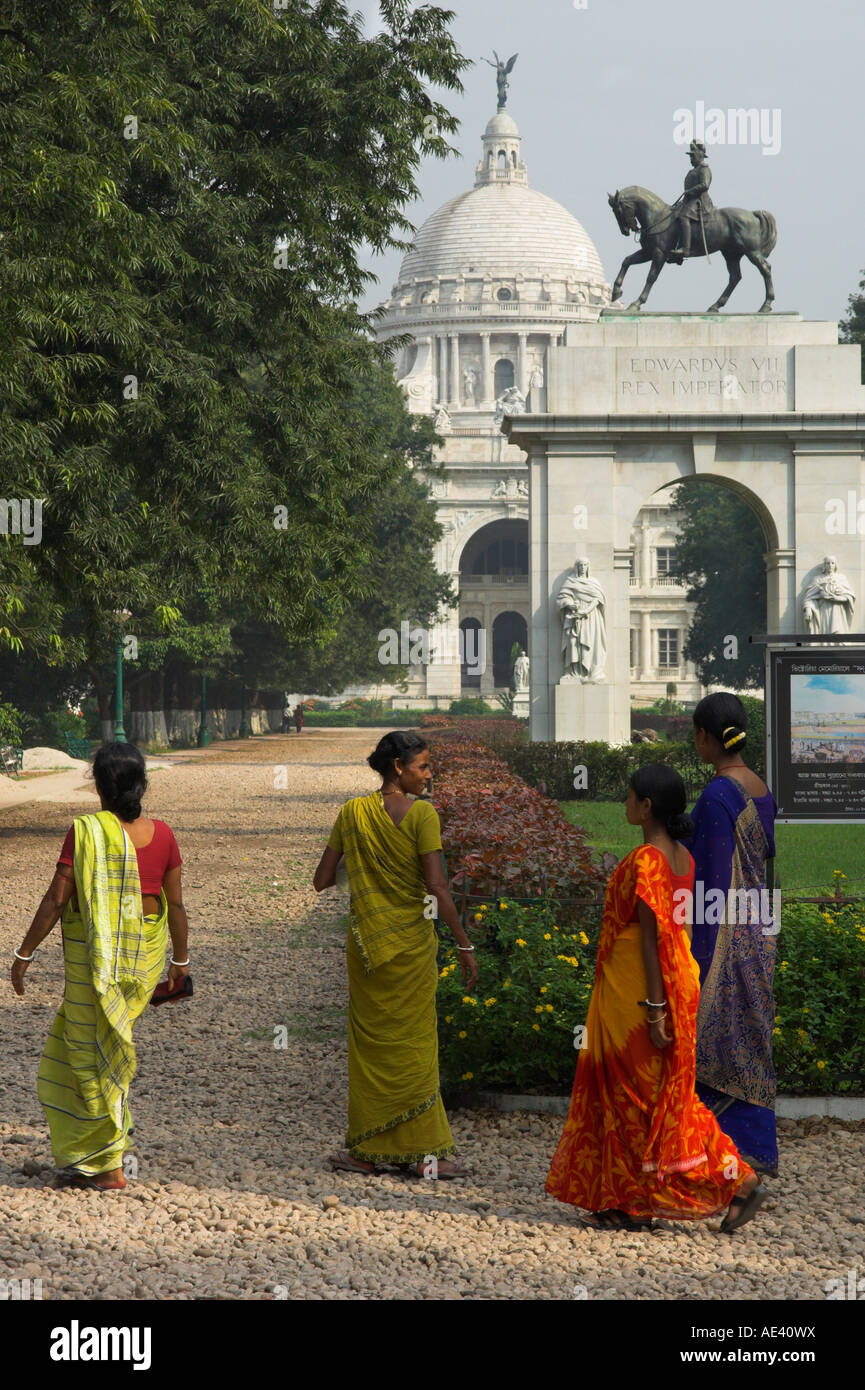 Women wearing colourful saris in the park with the Victoria Memorial ...