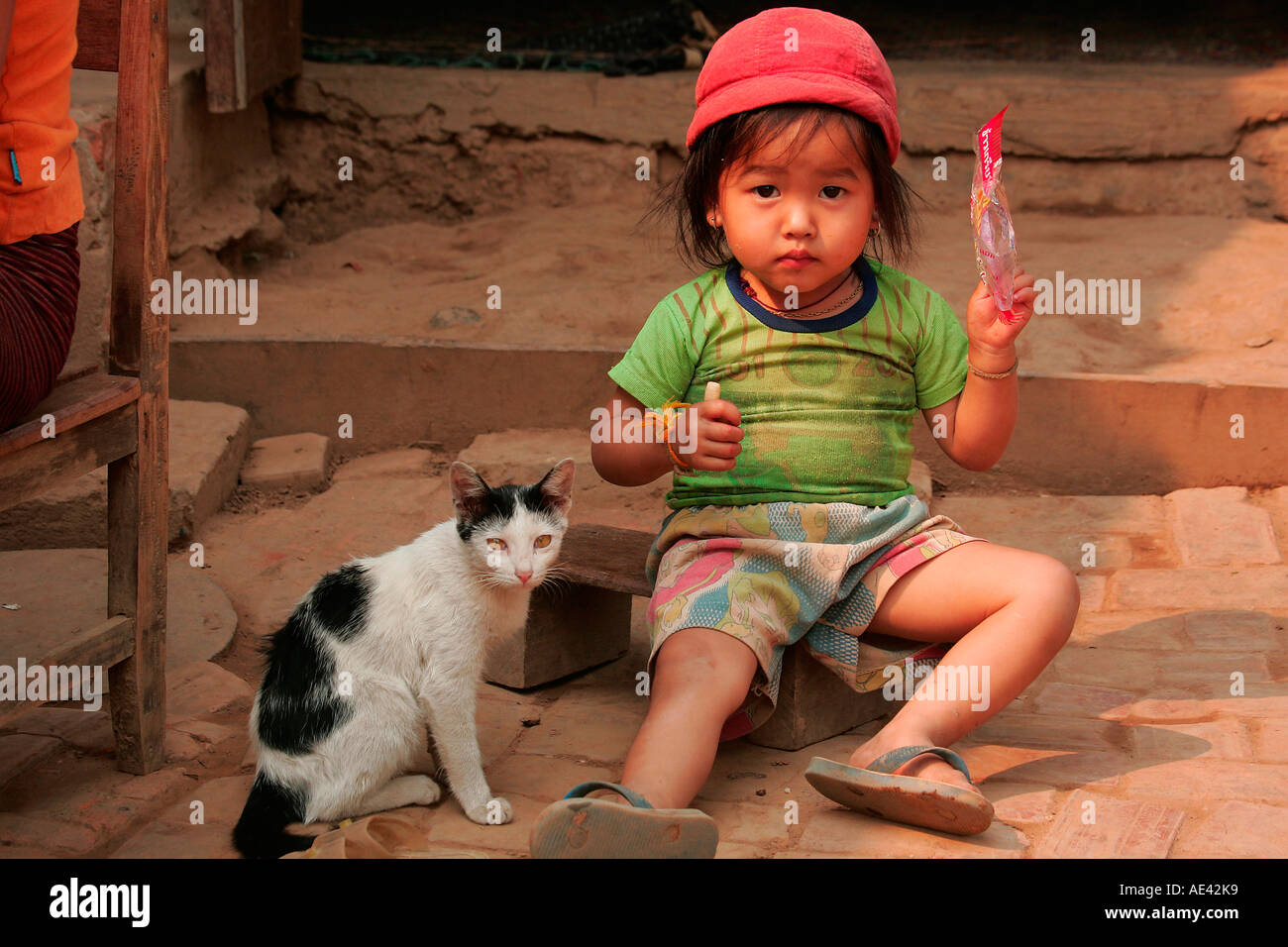 Native child and cat at Ban Chan village on the Mekong river near Luang ...