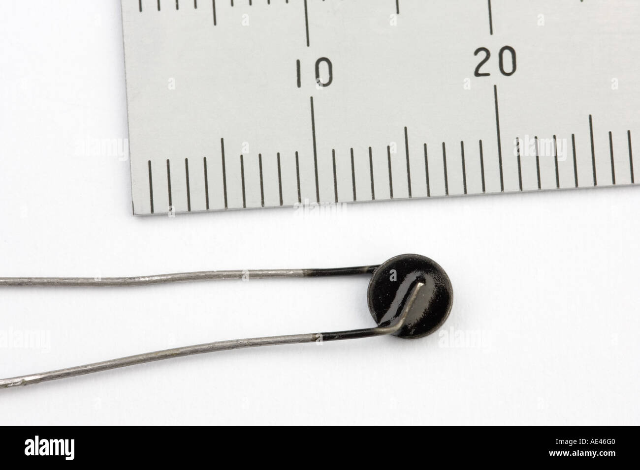 A disc type thermistor next to a ruler to show scale Stock Photo - Alamy