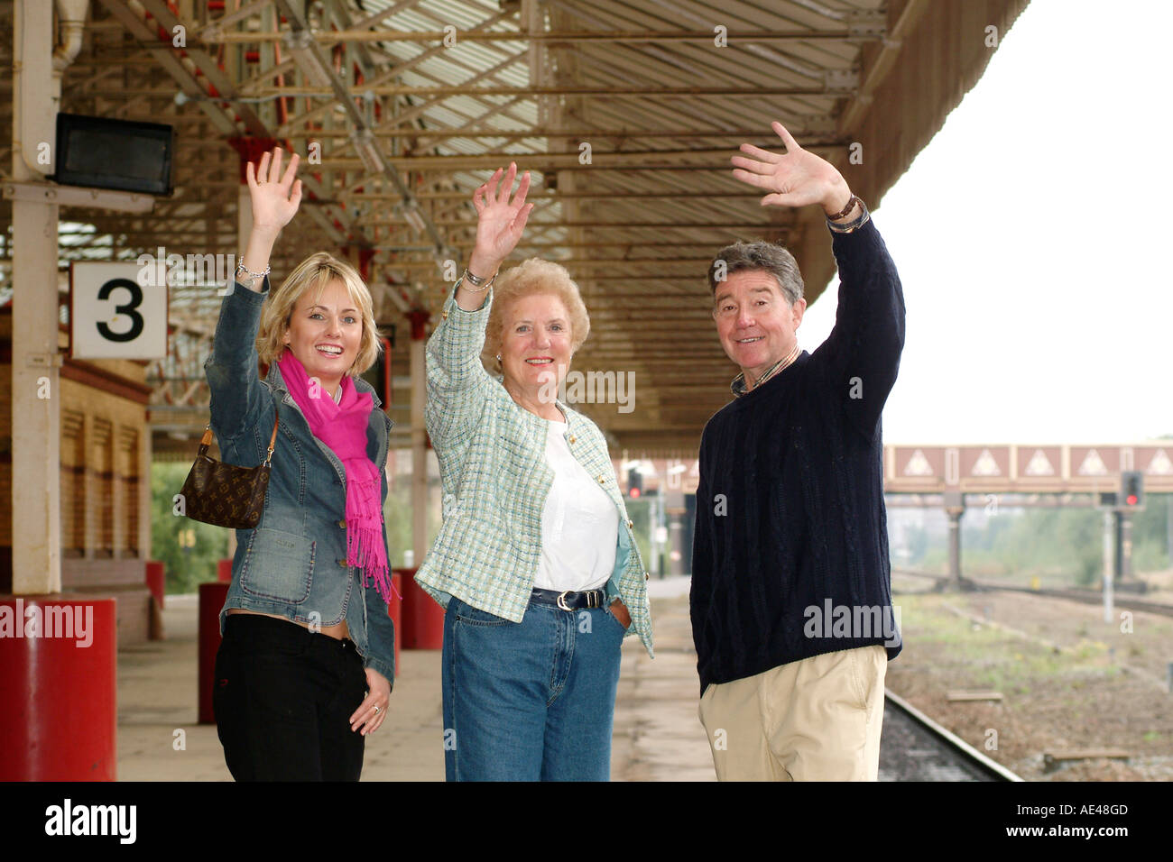 Family waving off a train from the platform at Bolton railway station ...