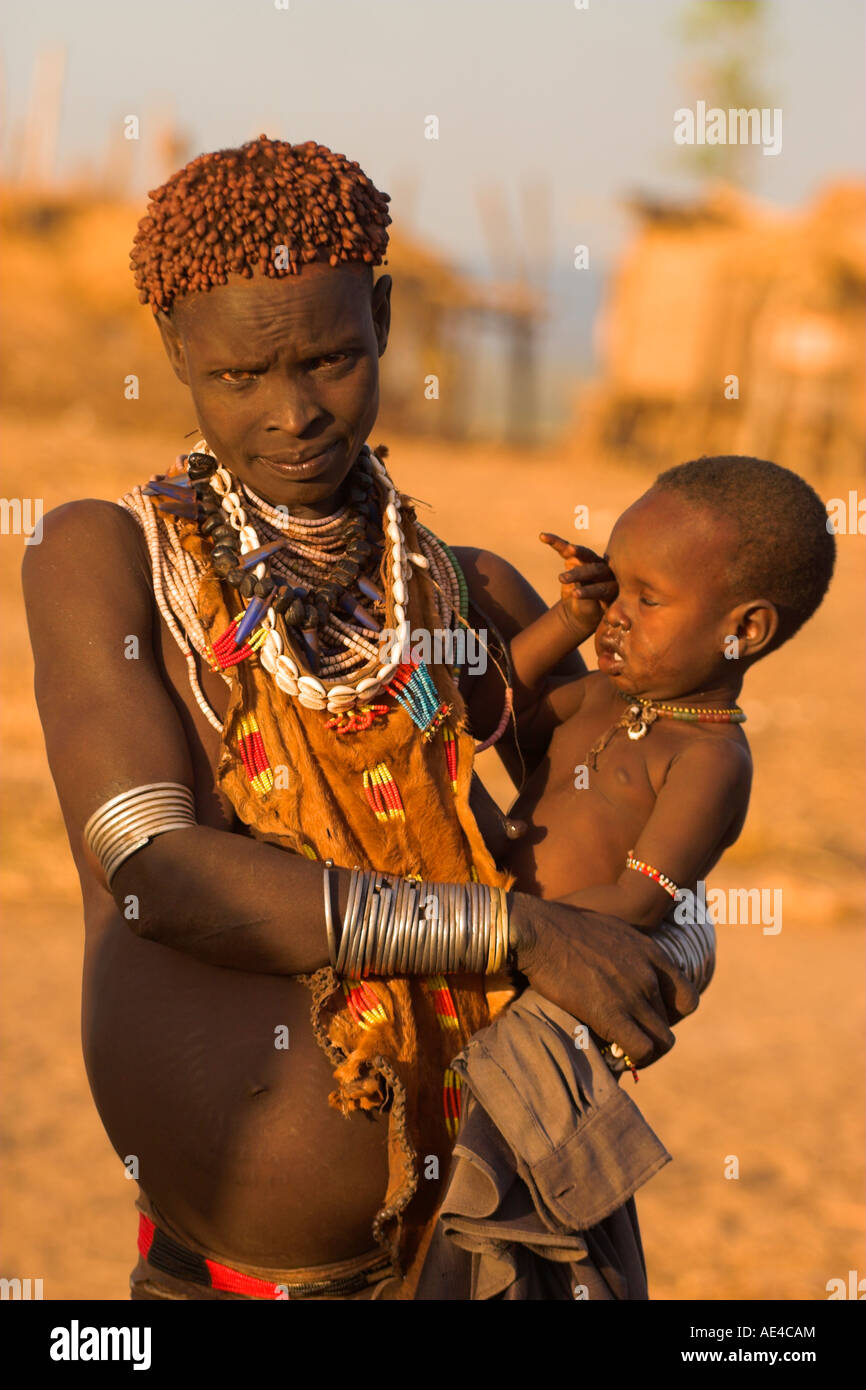 Karo woman with child wearing traditional goat skin dress decorated ...