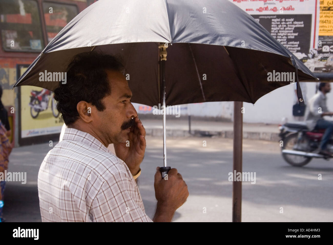 Man uses brolly to shade the sun Trivandrum Kerala India Stock Photo ...