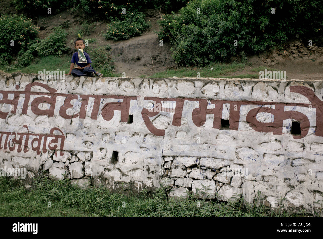 Nepalese child sat on wall Stock Photo - Alamy