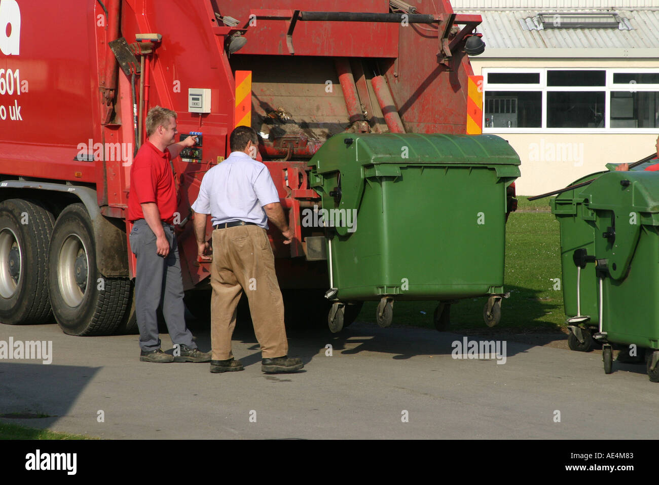 Men emptying commercial size dustbin into a lorry with automatic ...