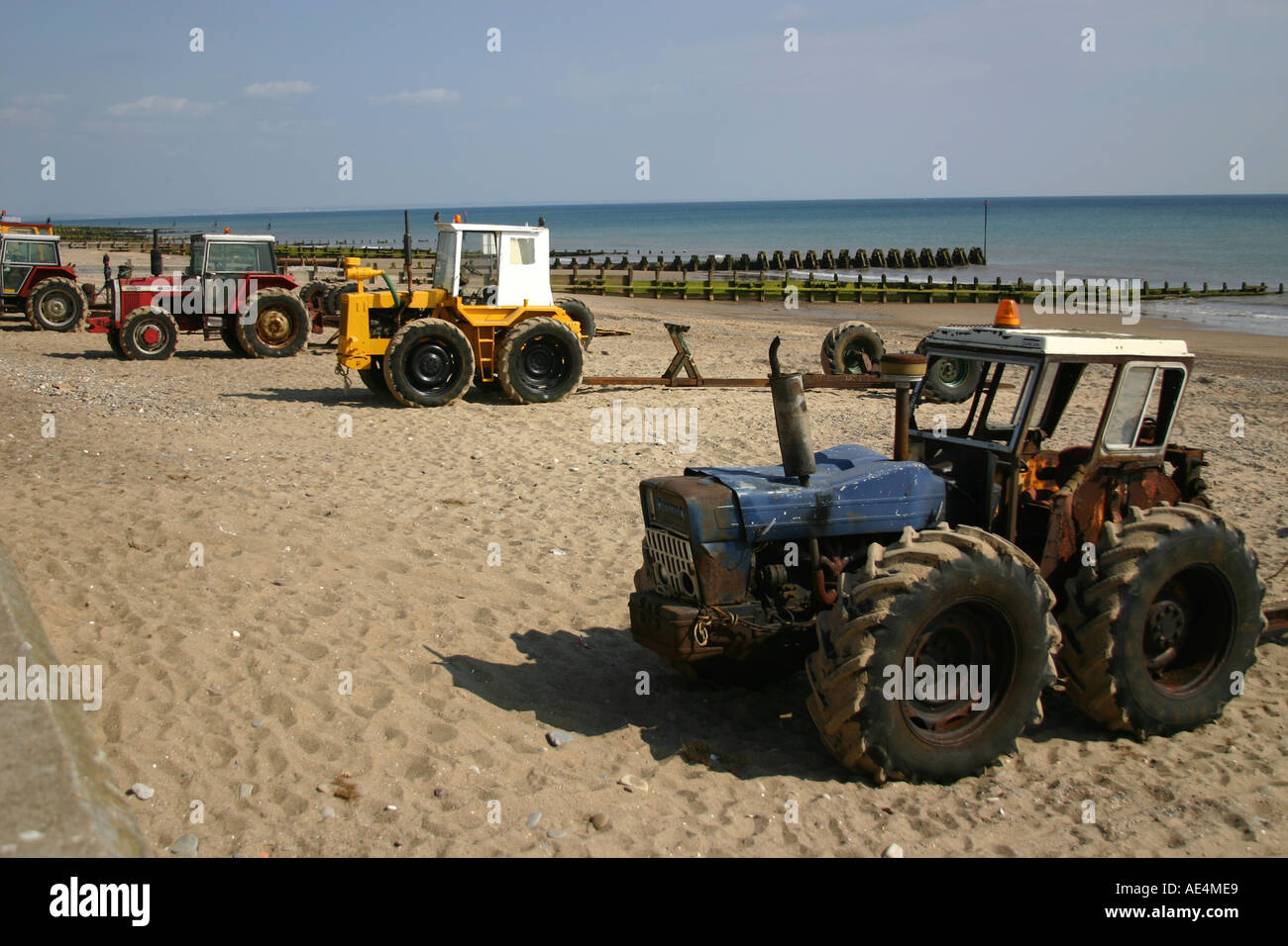 Old tractors with trailers on beach at Hornsea in North Yorkshire used ...
