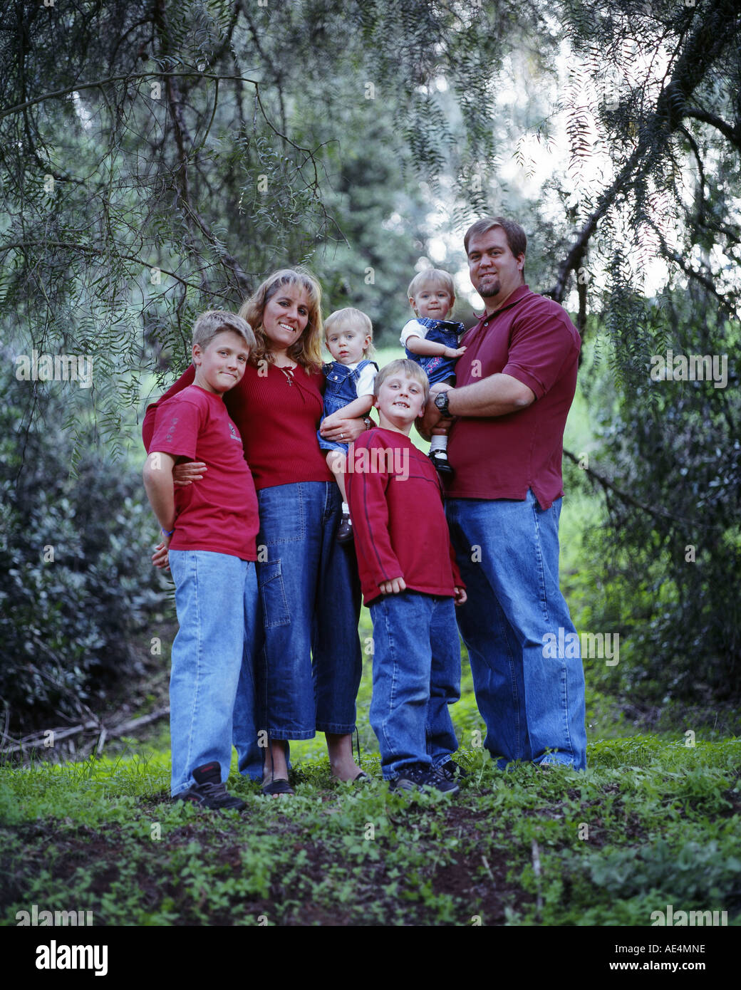 Happy family under pepper trees Stock Photo - Alamy