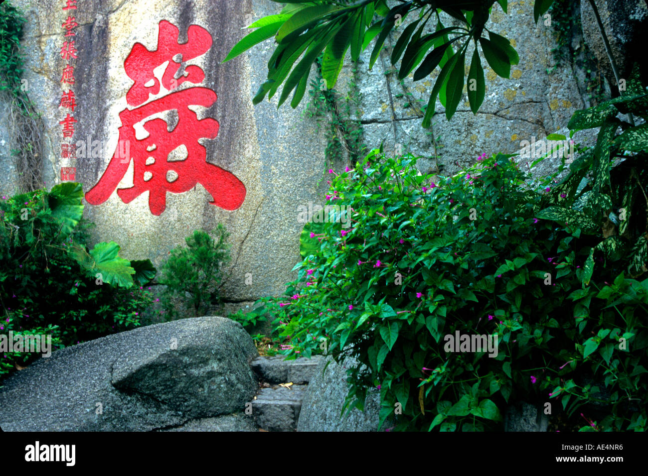 Chinese writing adorns stone wall in A-Ma Temple's peaceful rock garden ...