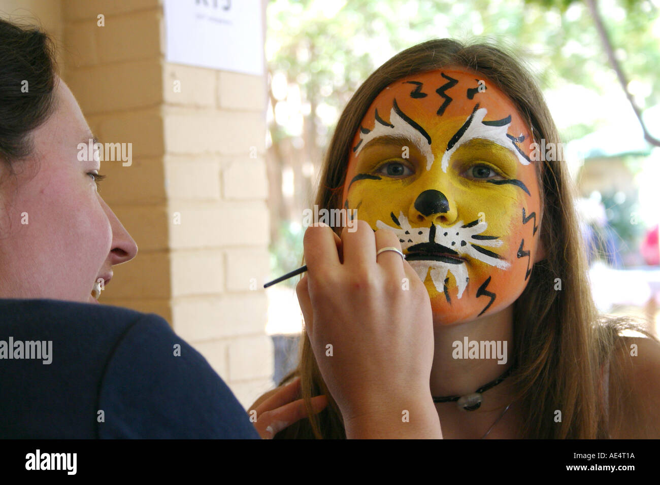 Woman face painting at funfair Stock Photo - Alamy