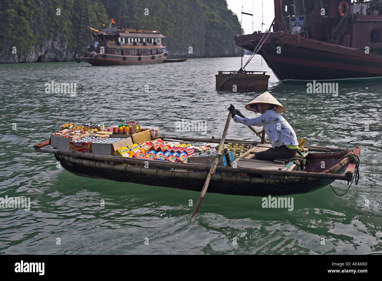 Woman rows floating supply boat with biscuits drinks cooking oil and ...