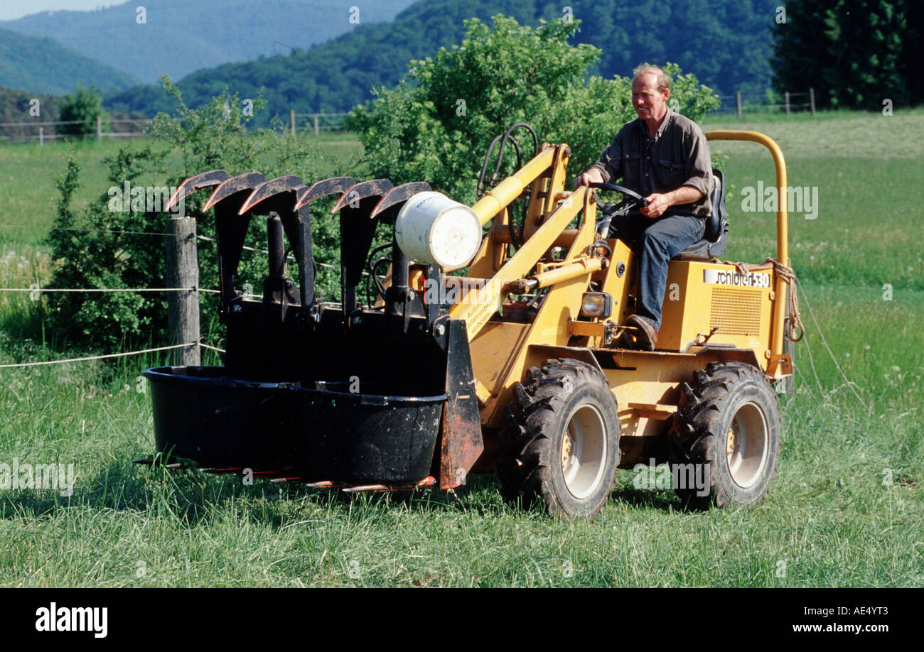Landwirt bei der Arbeit Traenke fuer das Vieh wird nach Fuellung auf ...
