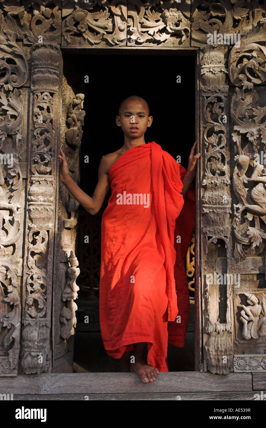 Monk standing in doorway of traditional wooden monastery, Shwenandaw ...