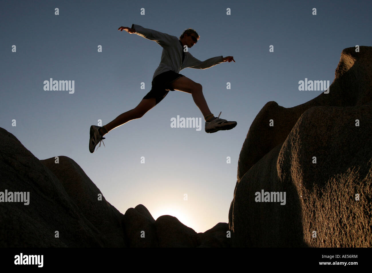 Boy leaping between rocks at Campomoro, Corsica, France Stock Photo - Alamy