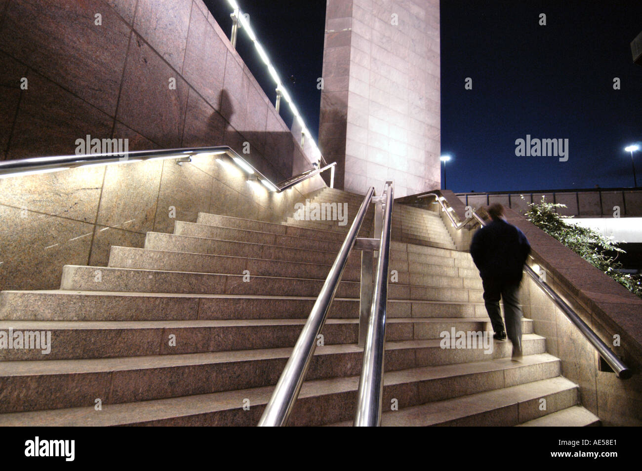 Man walking up steps at night, London England UK Stock Photo - Alamy