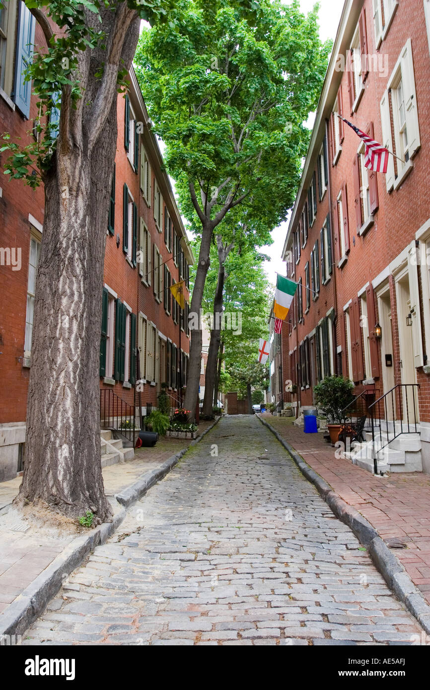 Narrow cobblestone tree lined street with Georgian brick row house in ...