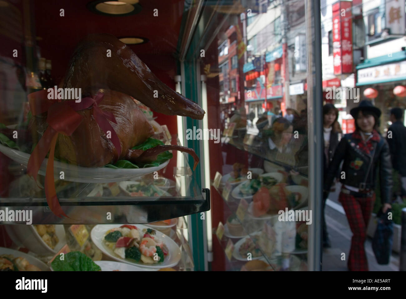People walk by a window displaying Chinese food in a restaurant in ...
