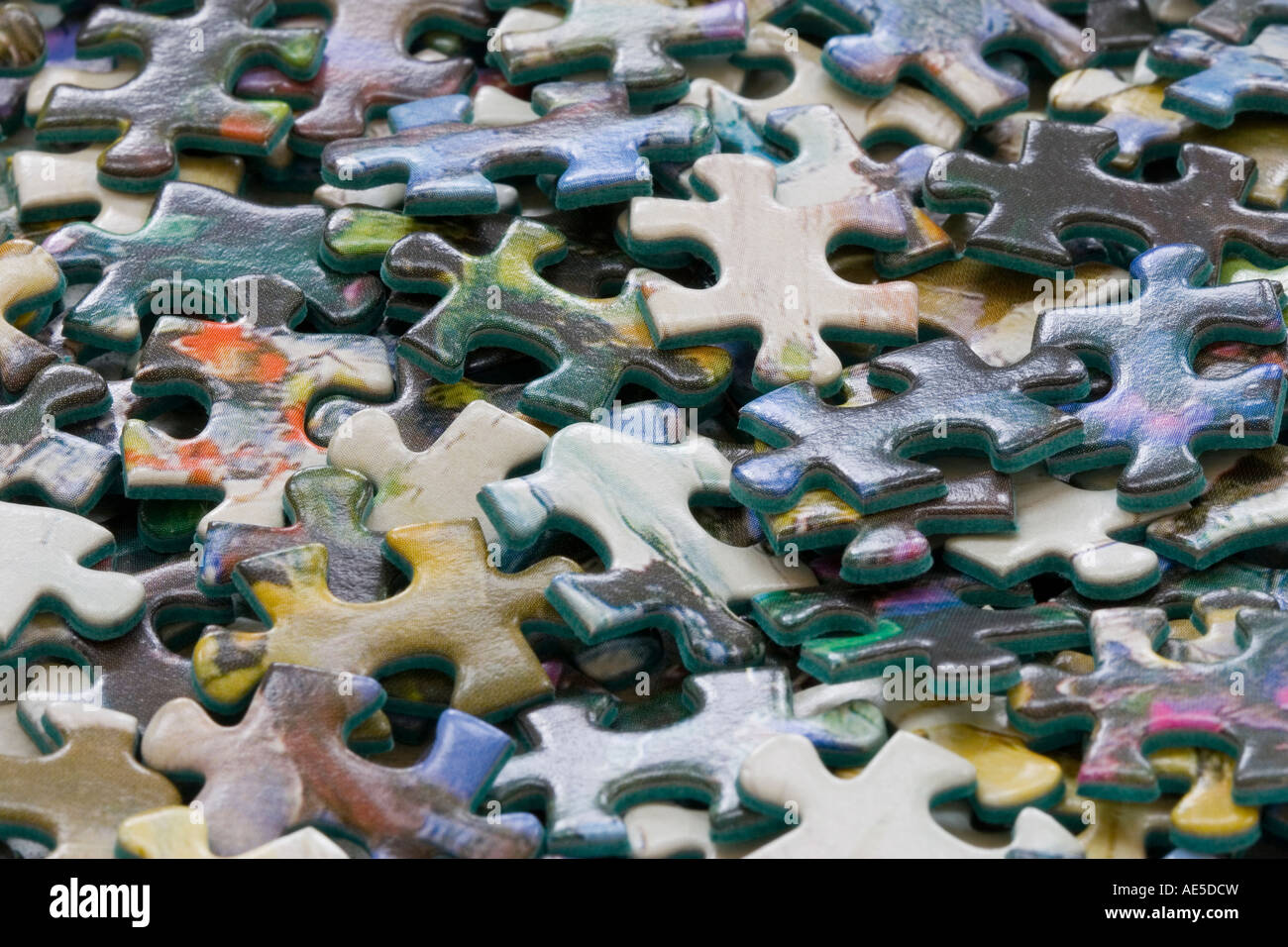 Closeup of the pieces of a jigsaw puzzle in a pile conveys idea of ...